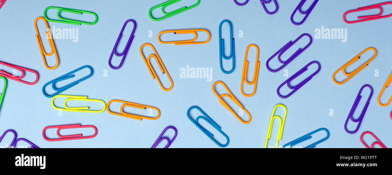 Color clips minimal concept. Colored paper clips on a colored ...