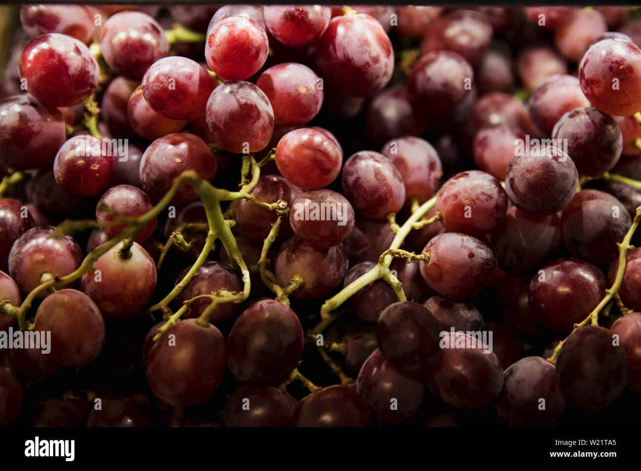 A close-up shot of an abundance of fresh Red Grapes on display at a ...