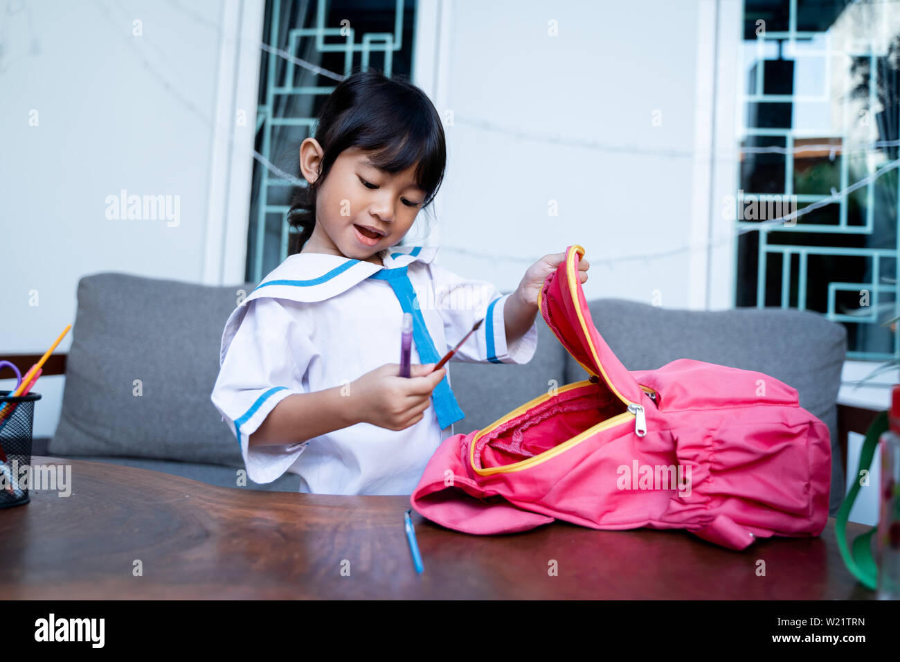 happy toddler with school uniform preparing her self and put some ...