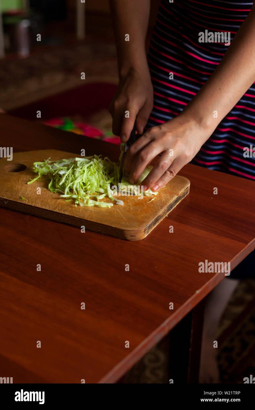 Housewife making a salad from fresh healthy vegetables. Young woman ...