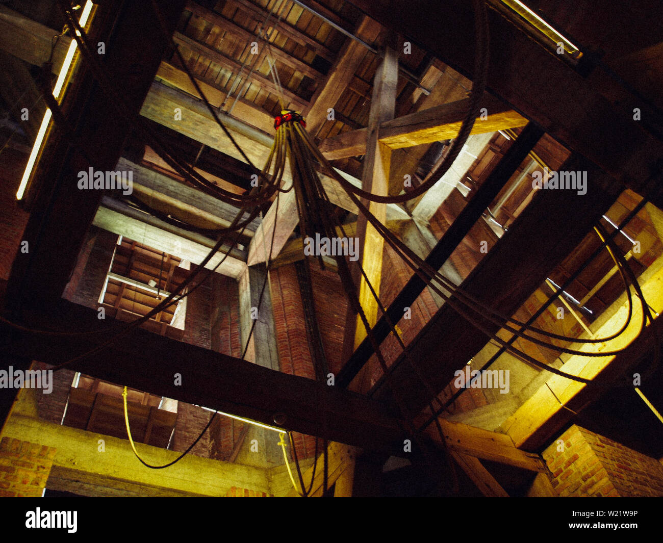 Belfry interior in old village bell tower, wooden beams, stair, bells ...