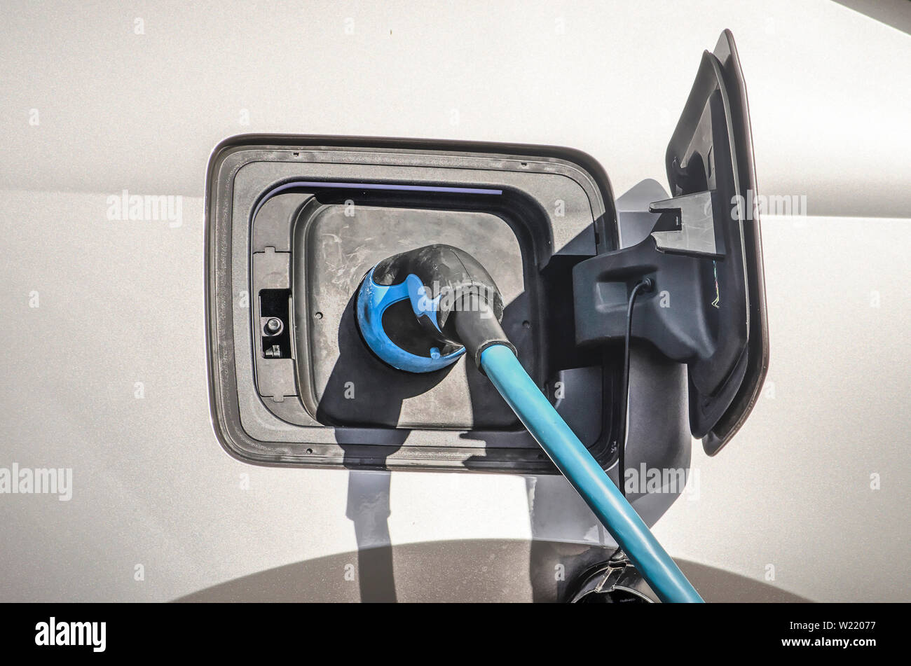 Blue charging cable connected to the charging console of a light grey ...