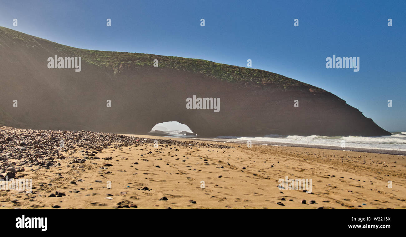 Red rock formation with arch on the beach, Plage Sidi Ifni, Morocco ...