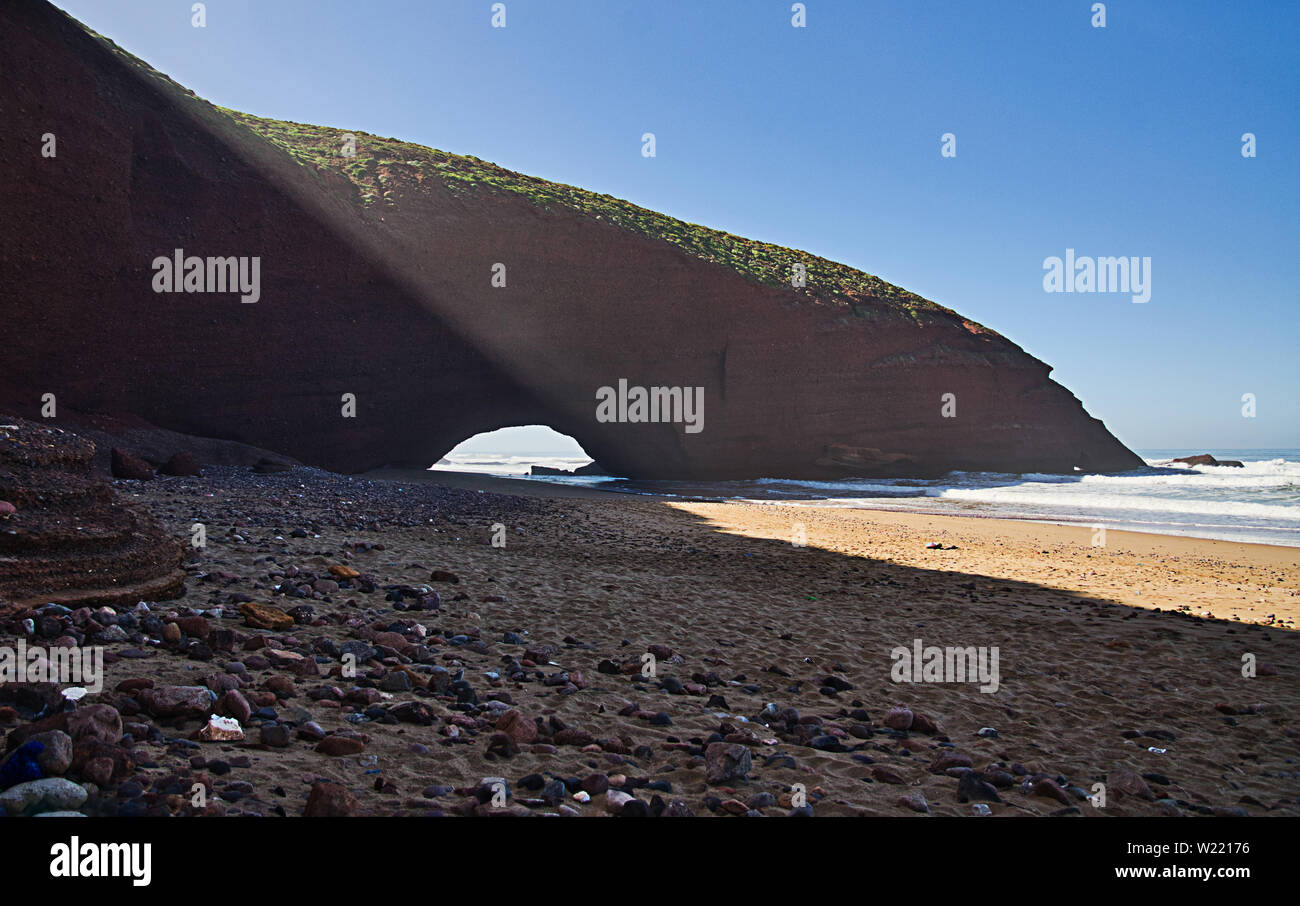 Red rock formation with arch on the beach, Plage Sidi Ifni, Morocco ...