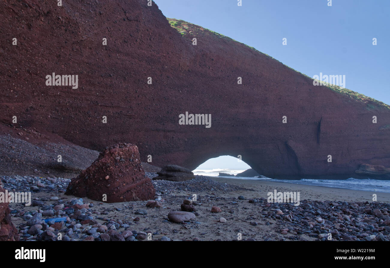 Red rock formation with arch on the beach, Plage Sidi Ifni, Morocco ...