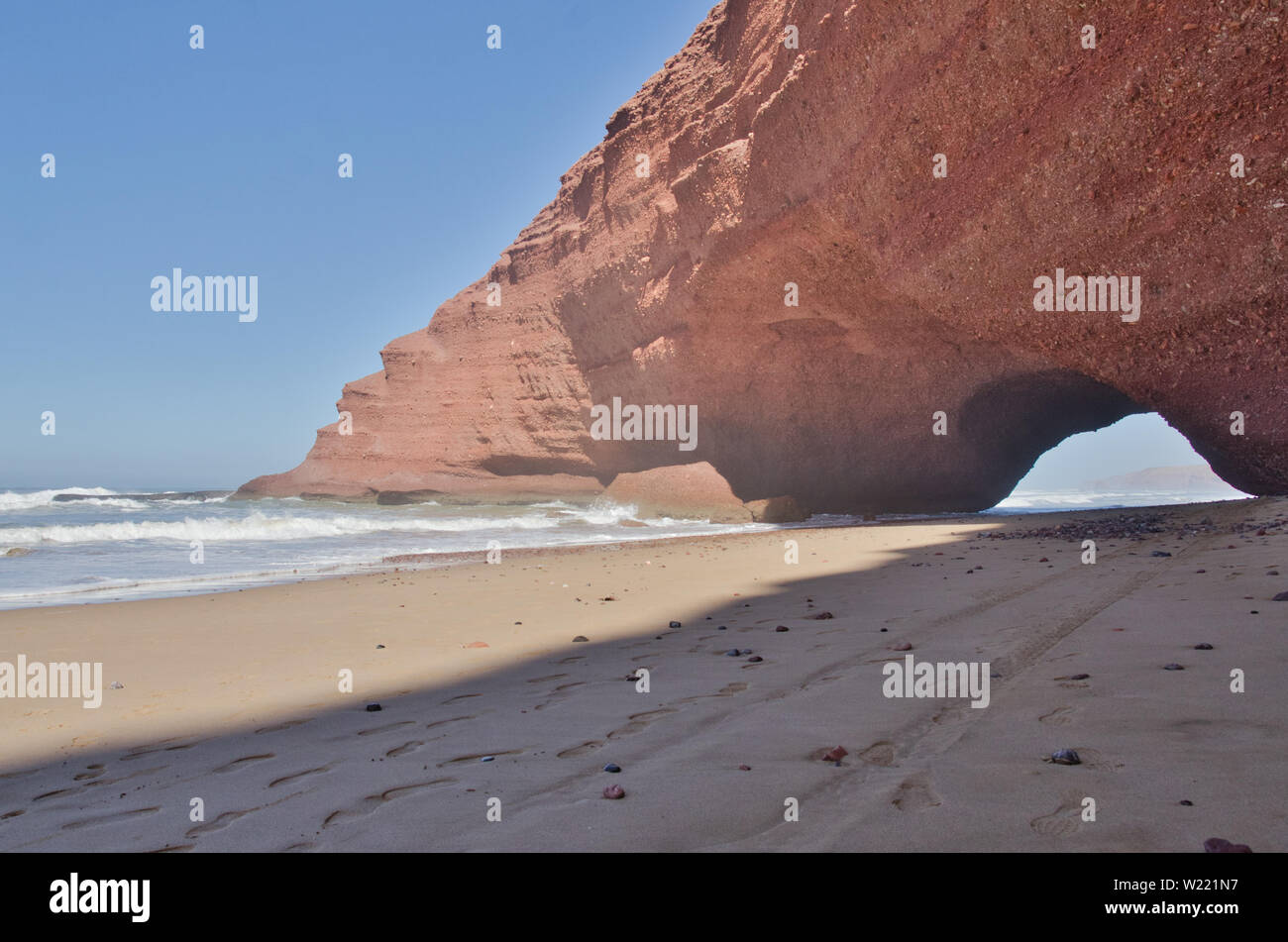 Red rock formation with arch on the beach, Plage Sidi Ifni, Morocco ...