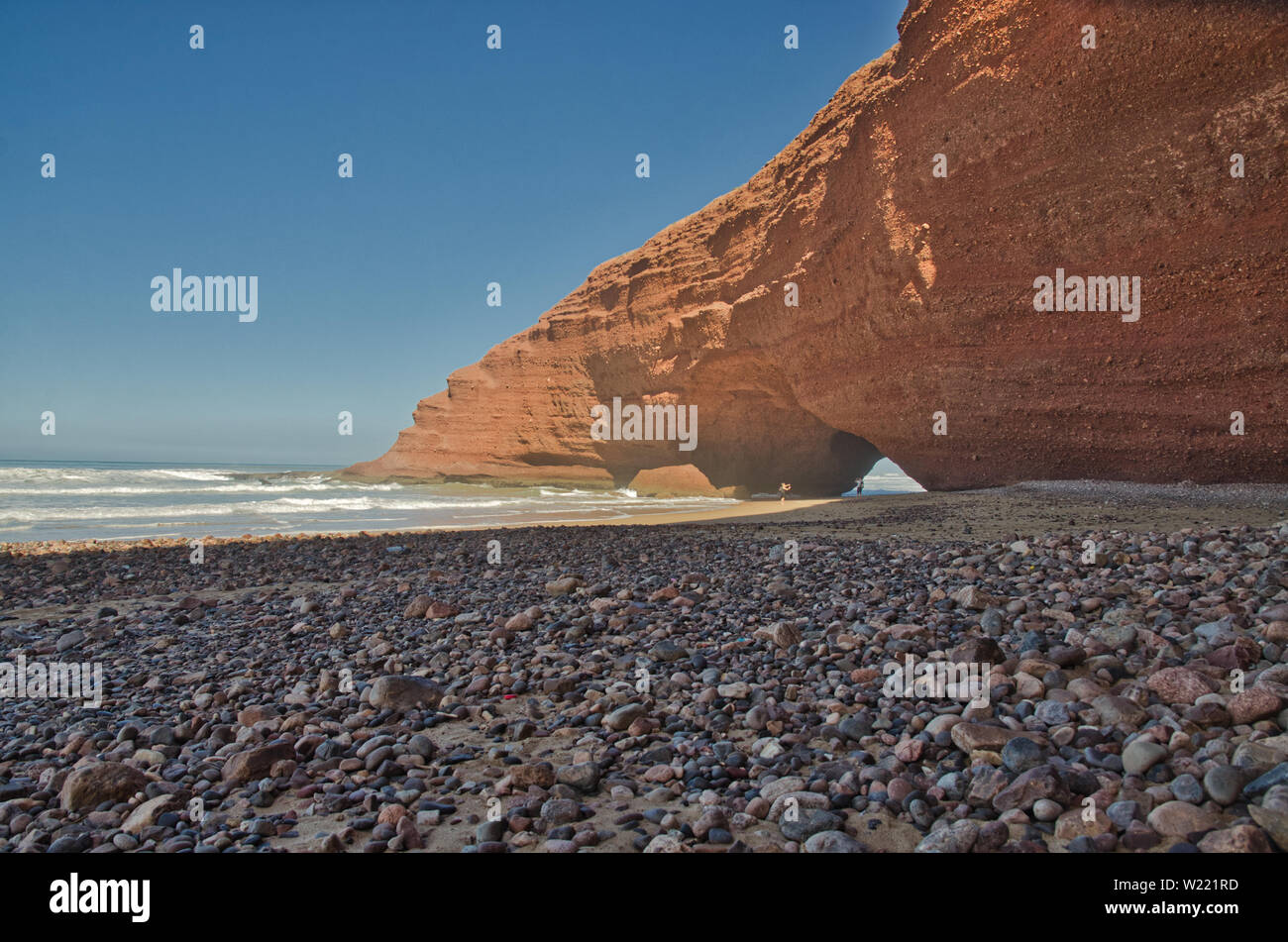 Red rock formation with arch on the beach, Plage Sidi Ifni, Morocco ...