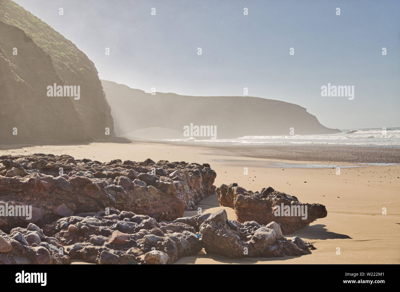 Red rock formation with arch on the beach, Plage Sidi Ifni, Morocco ...