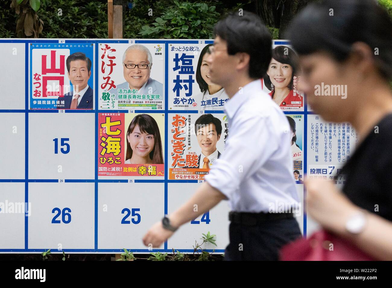 Tokyo, Japan. 05th July, 2019. People walk past a poster board erected ...