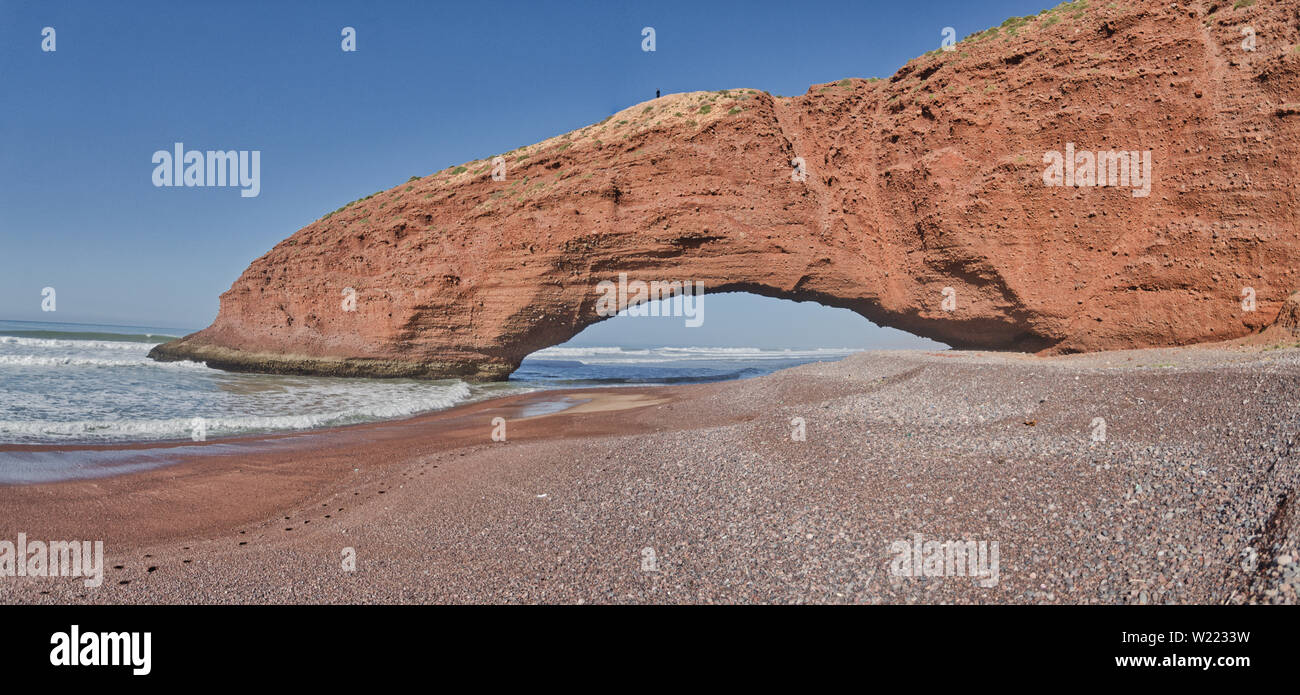 Red rock formation with arch on the beach, Plage Sidi Ifni, Morocco ...