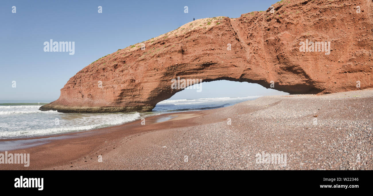 Red rock formation with arch on the beach, Plage Sidi Ifni, Morocco ...