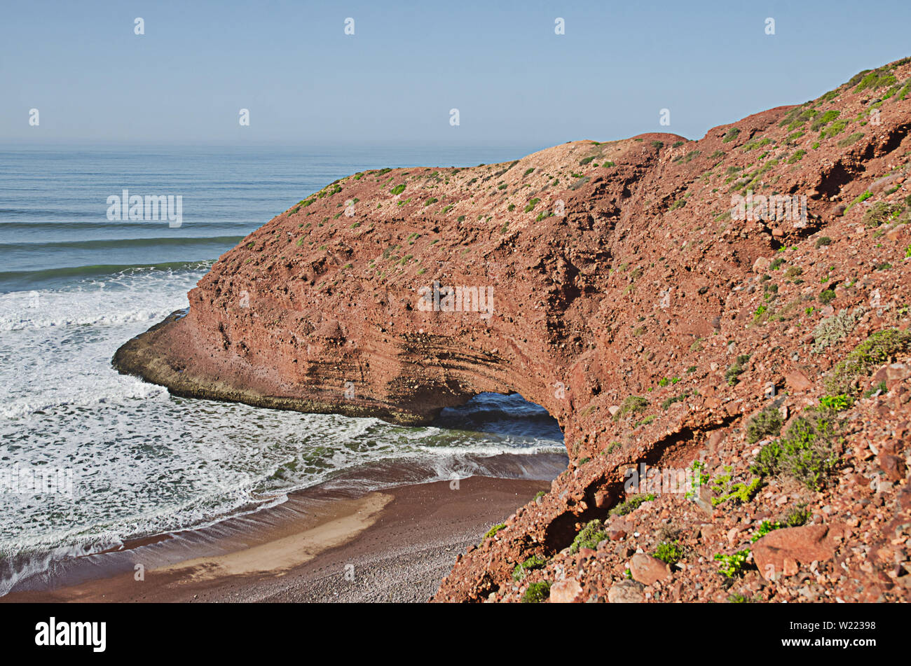 Red rock formation with arch on the beach, Plage Sidi Ifni, Morocco ...