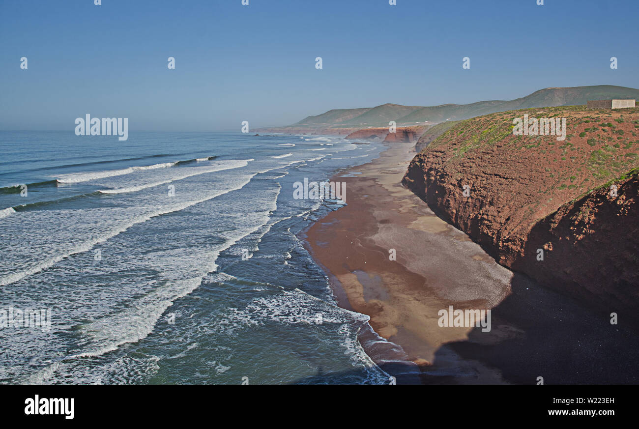 Red rock formation with arch on the beach, Plage Sidi Ifni, Morocco ...
