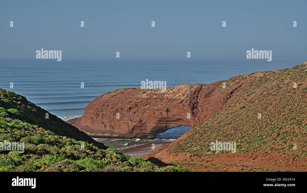 Red rock formation with arch on the beach, Plage Sidi Ifni, Morocco ...