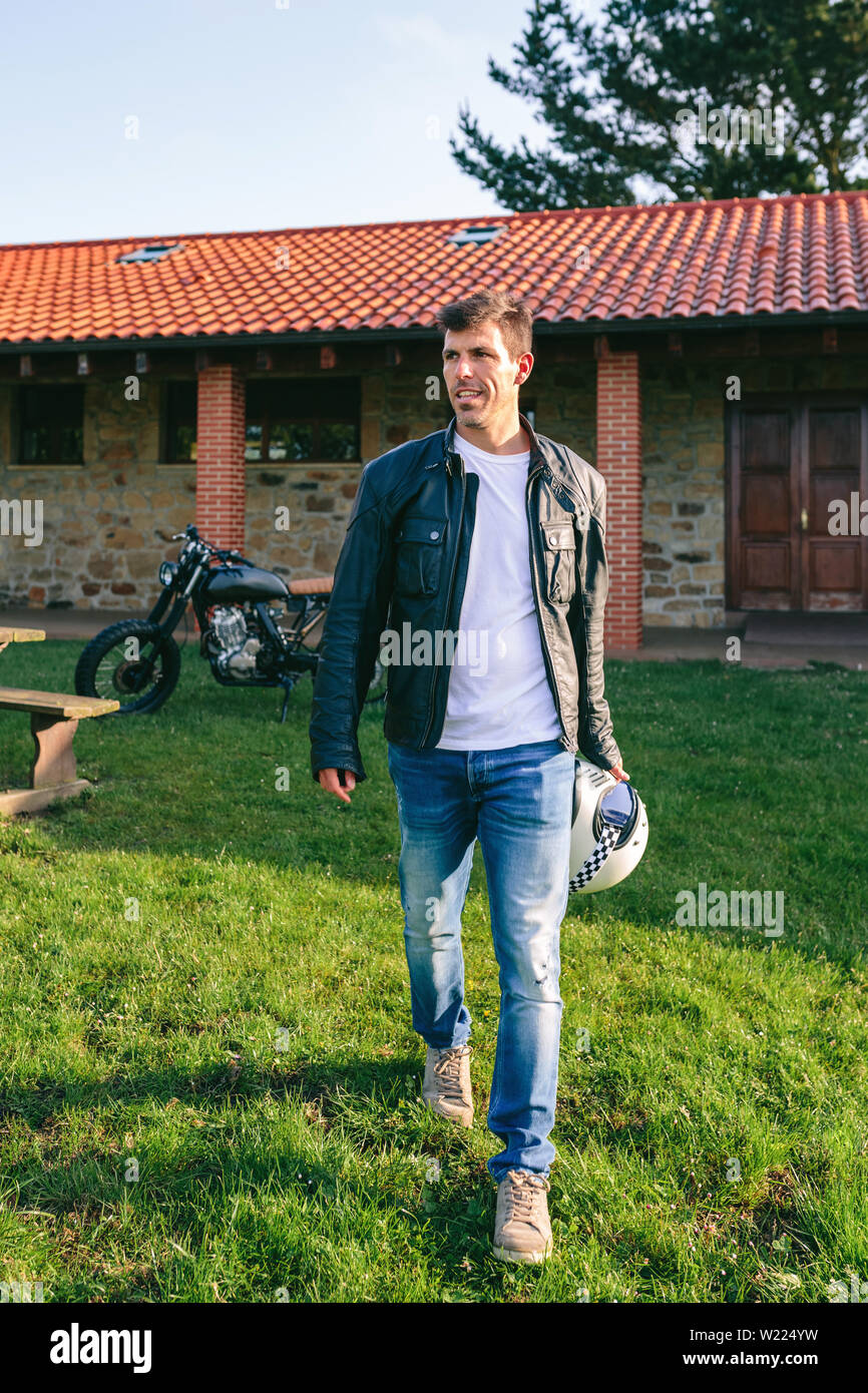 Man walking and custom motorcycle in background Stock Photo - Alamy