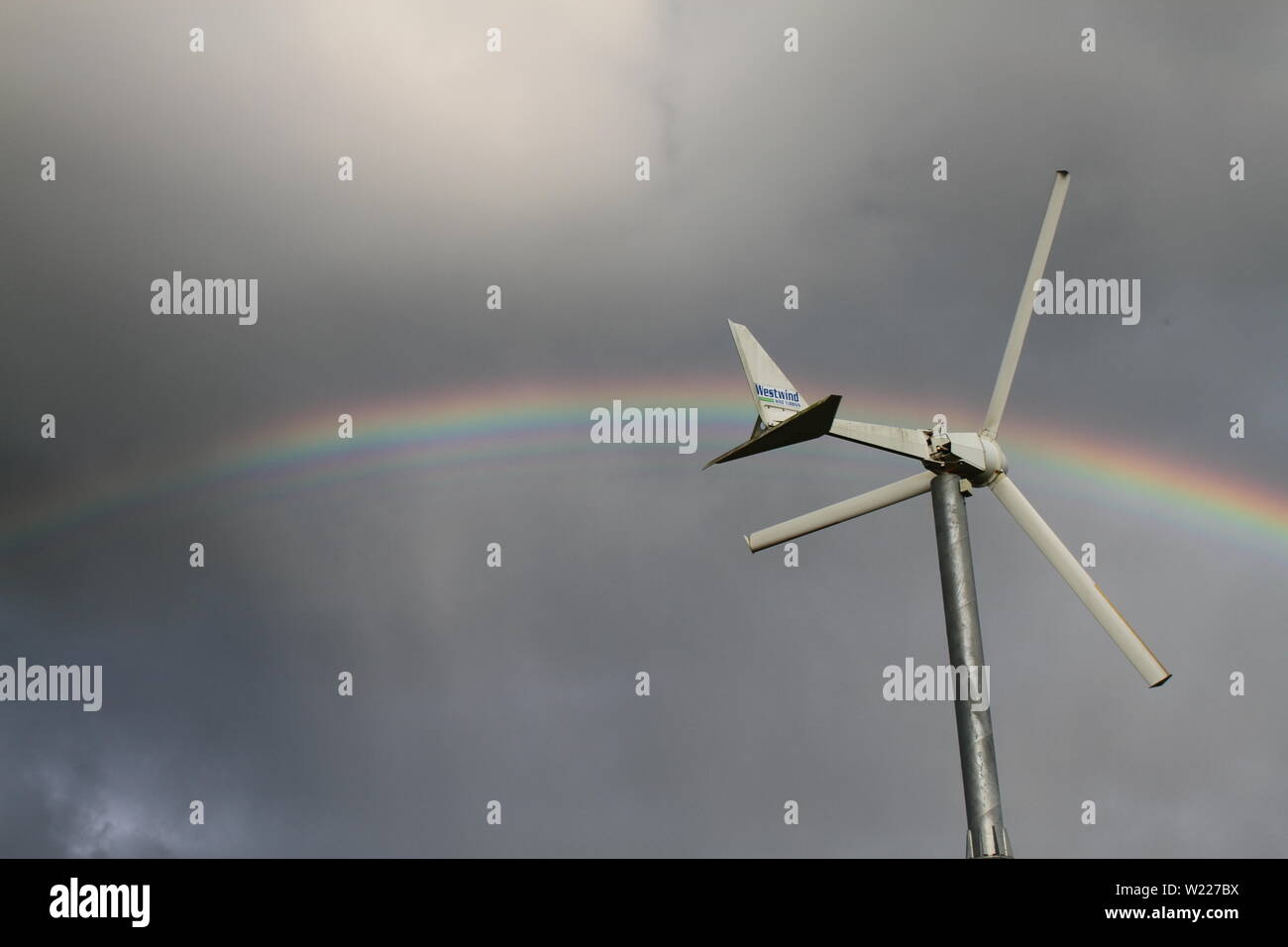 A windturbine with a rainbow seen just after a rainstorm Stock Photo ...
