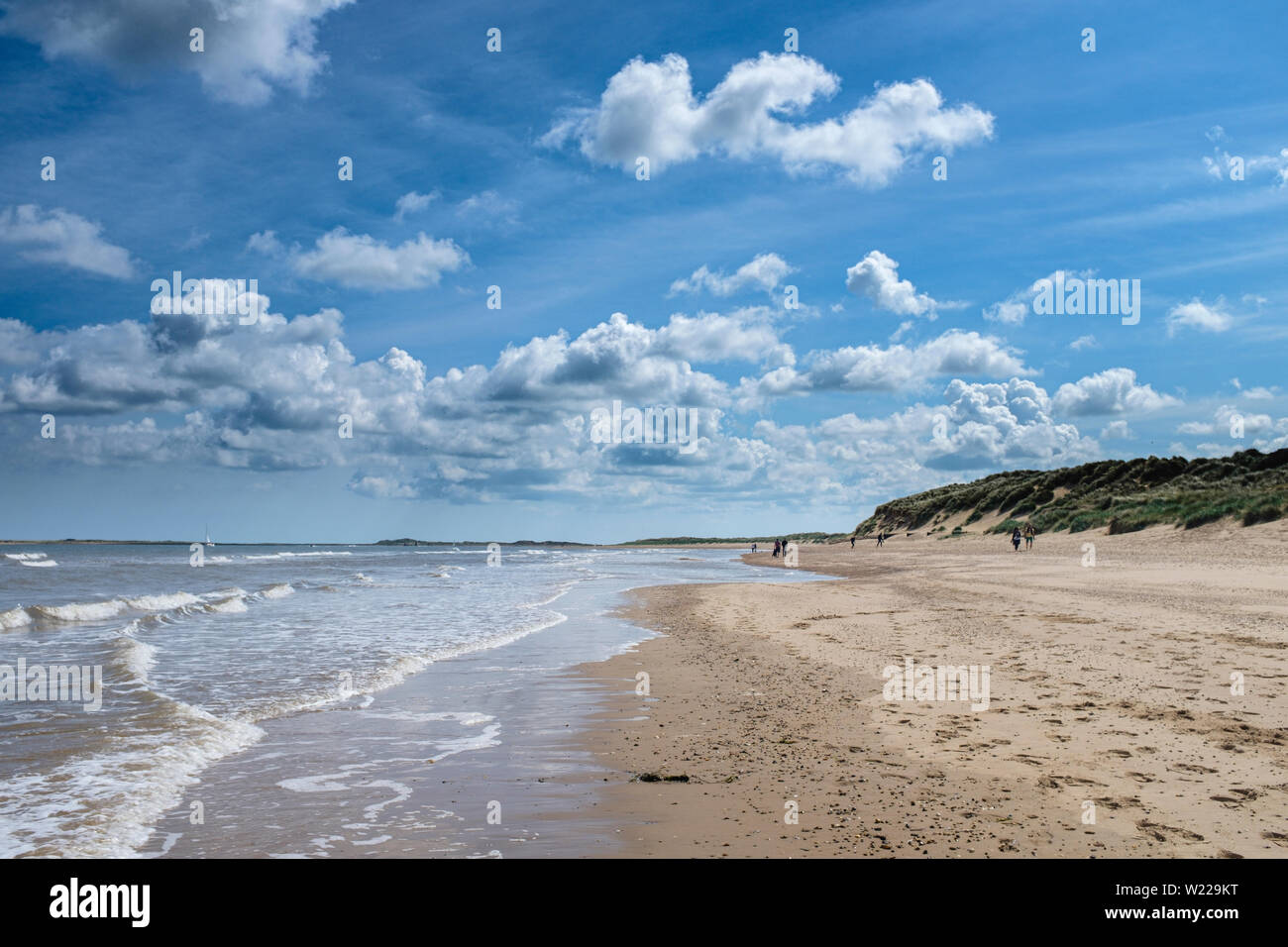 Enjoying the four miles of golden sand at Brancaster beach Stock Photo ...