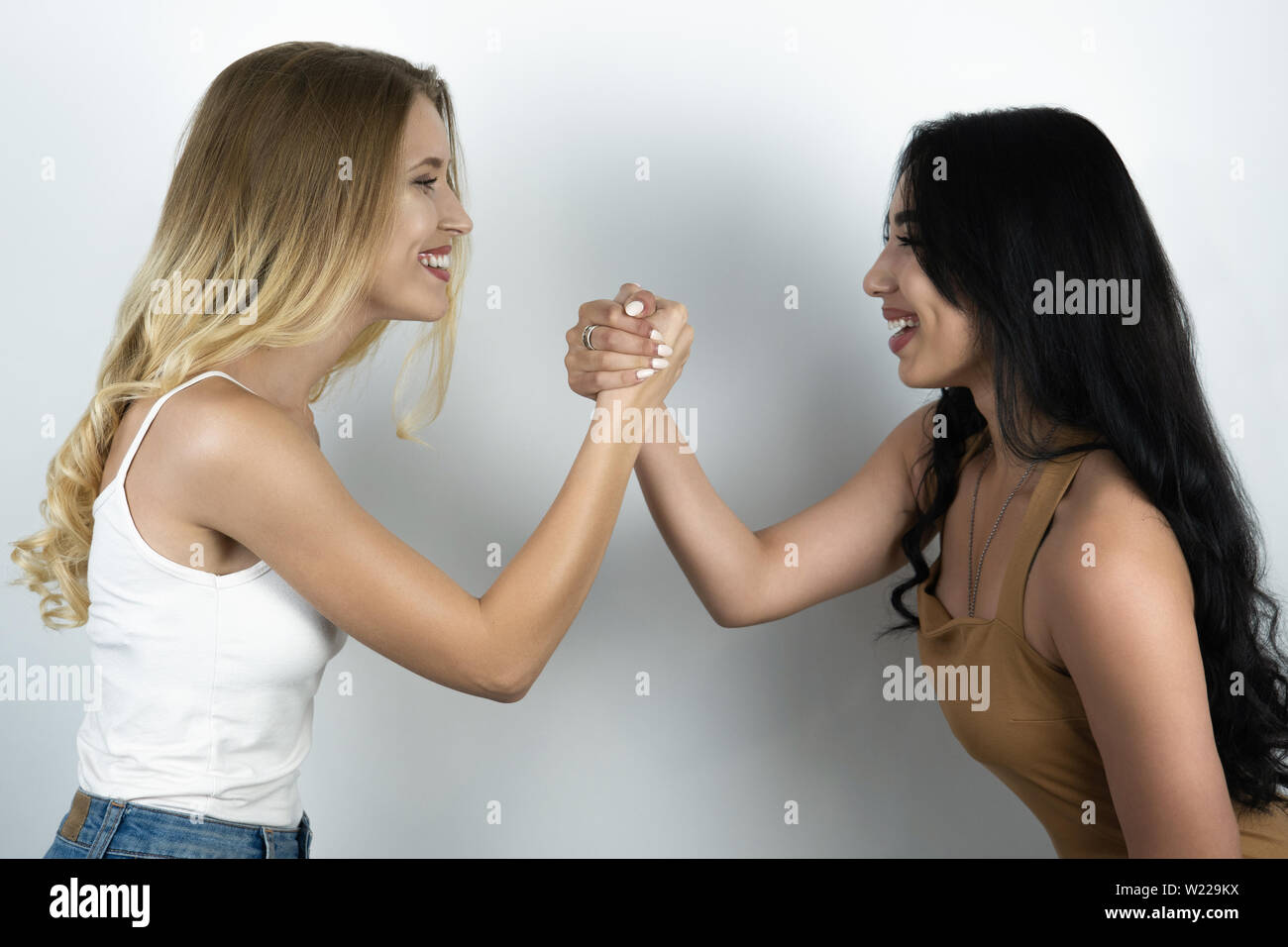positive confrontation between blonde and brunette white background ...