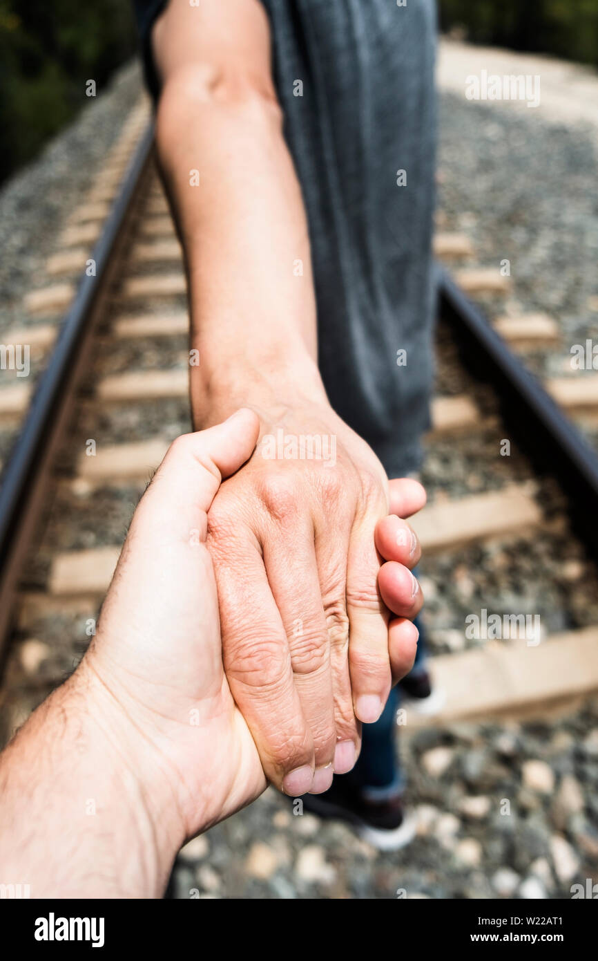 closeup of the hand of a man holding the hand of another man, seen from ...