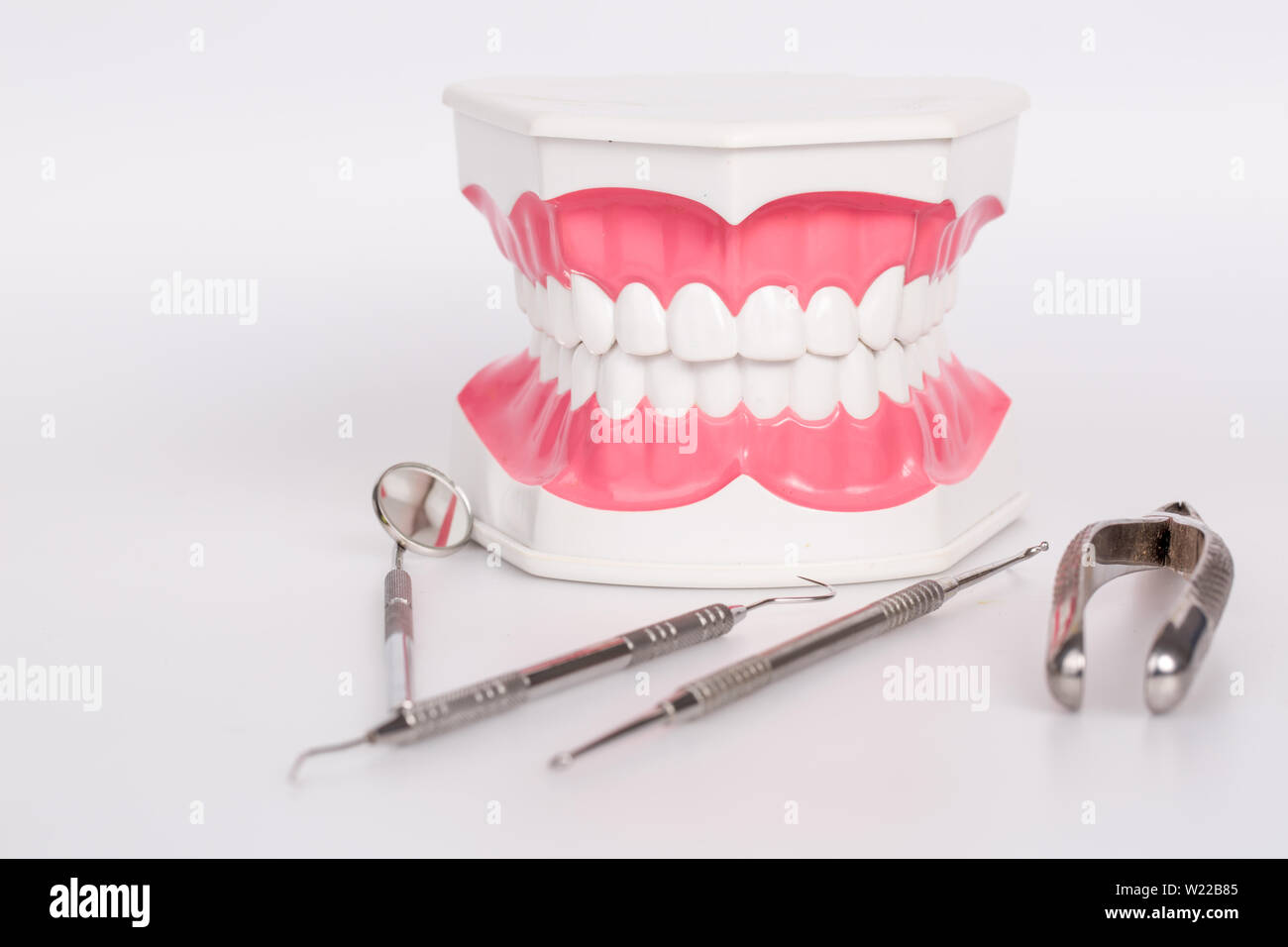 White teeth and dental instruments on white background Stock Photo - Alamy