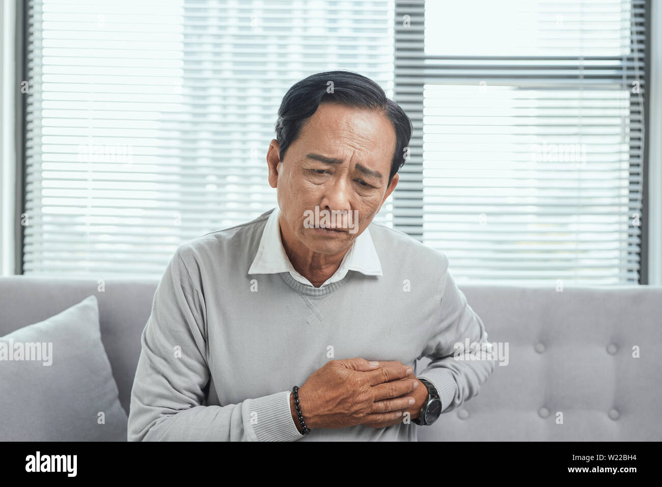 Old man feel pain in their heart in living room, medical concept Stock ...
