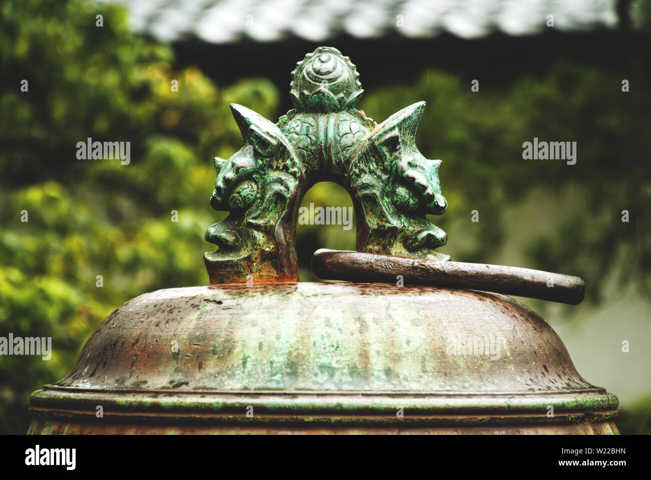 closeup of a sculpture on top of an ancient japanese copper bell at the ...