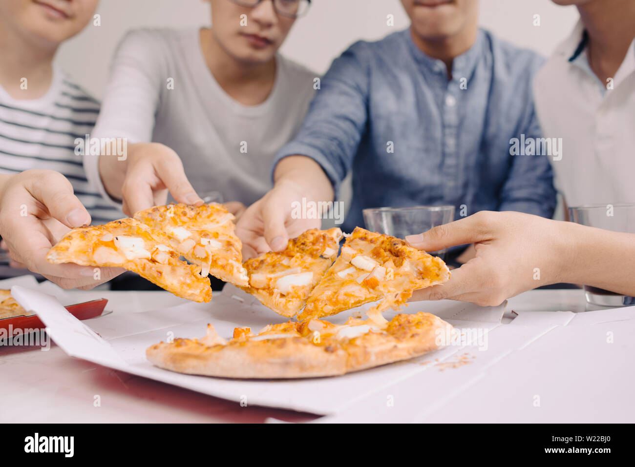 Business team is eating pizza at work while working Stock Photo - Alamy