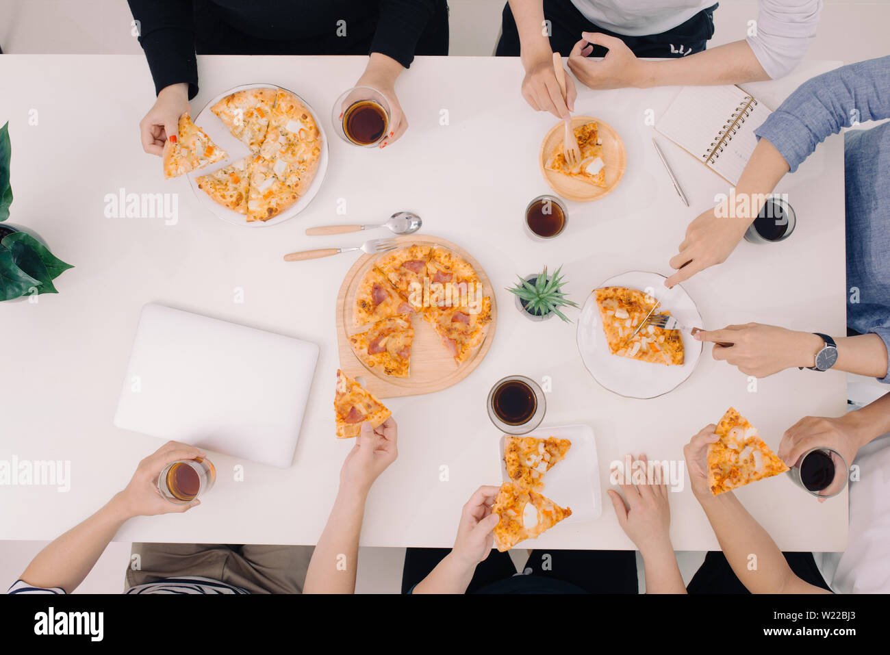 Business team is eating pizza at work while working Stock Photo - Alamy