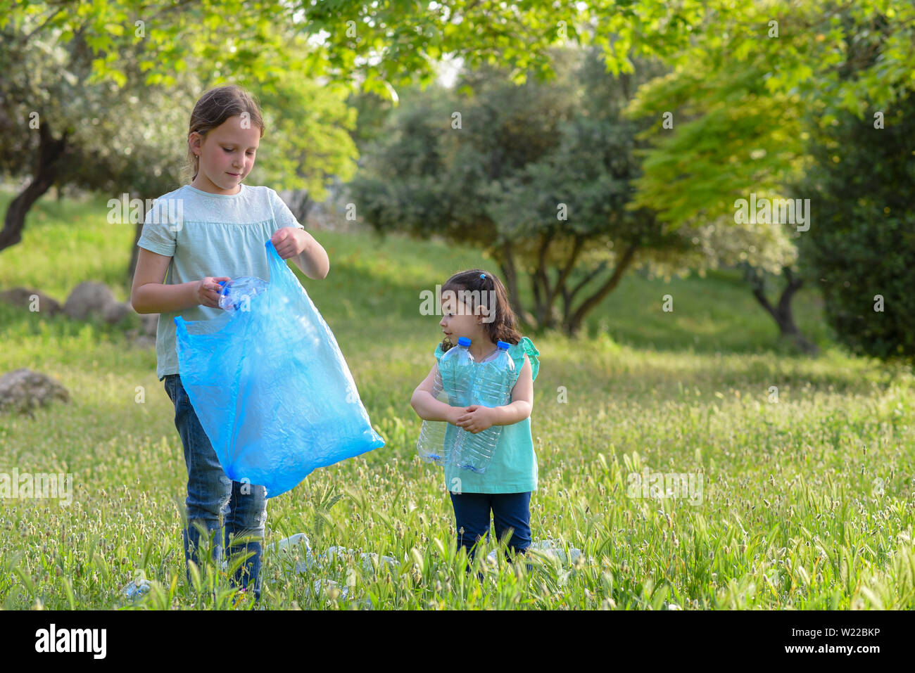 Two kids volunteer charity environment.Children with garbage bags ...
