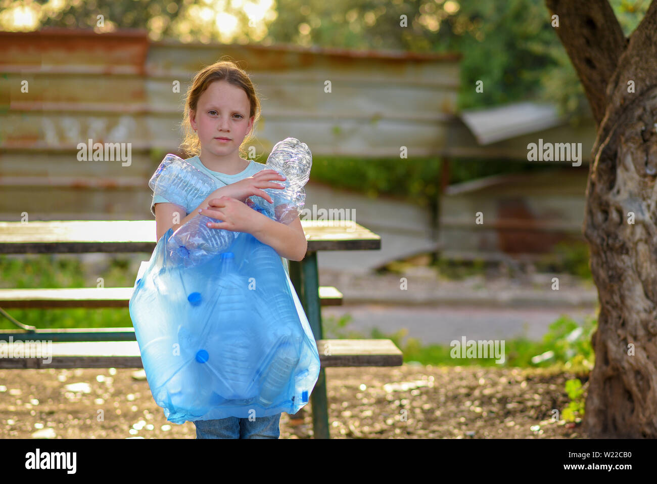 Young teenage girl recycling plastic bottles.Kid volunteers with ...