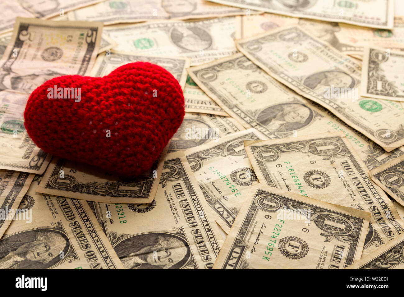 Red heart woven on dollar currency bills, love of money Stock Photo - Alamy