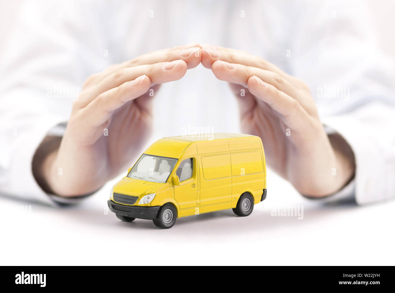 Transport yellow van car protected by hands Stock Photo - Alamy