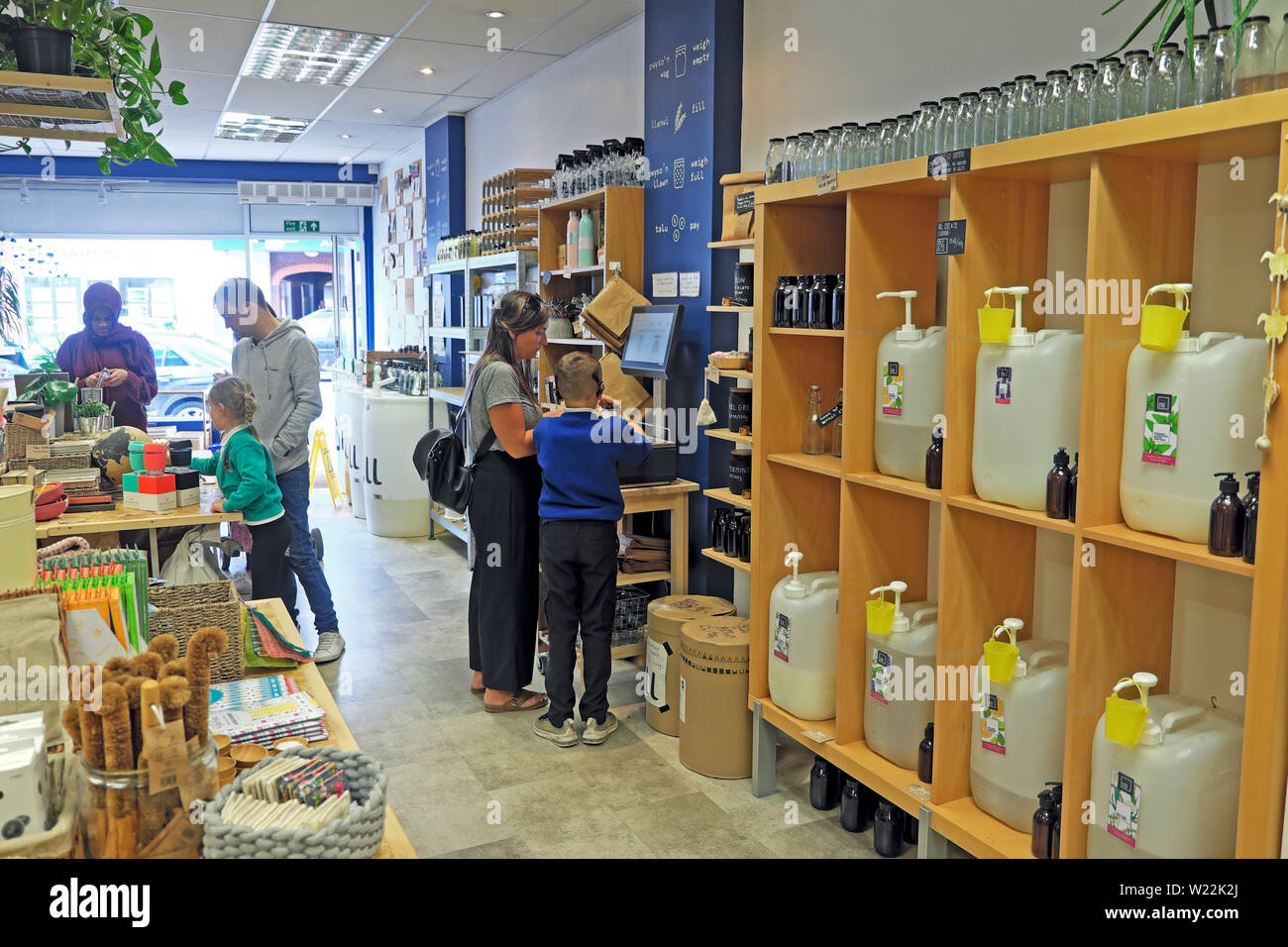 Woman child weighing and refilling containers shopping zero waste ...
