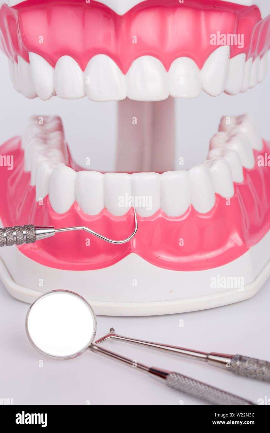 White teeth and dental instruments on white background Stock Photo - Alamy