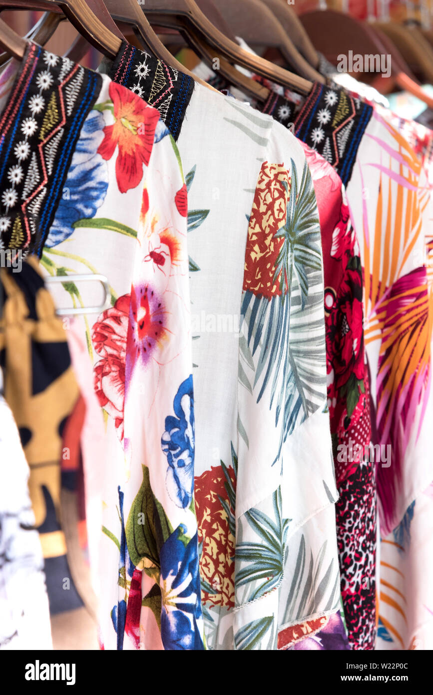 Clothes in multiple colors hangs from a rack at a store Stock Photo - Alamy