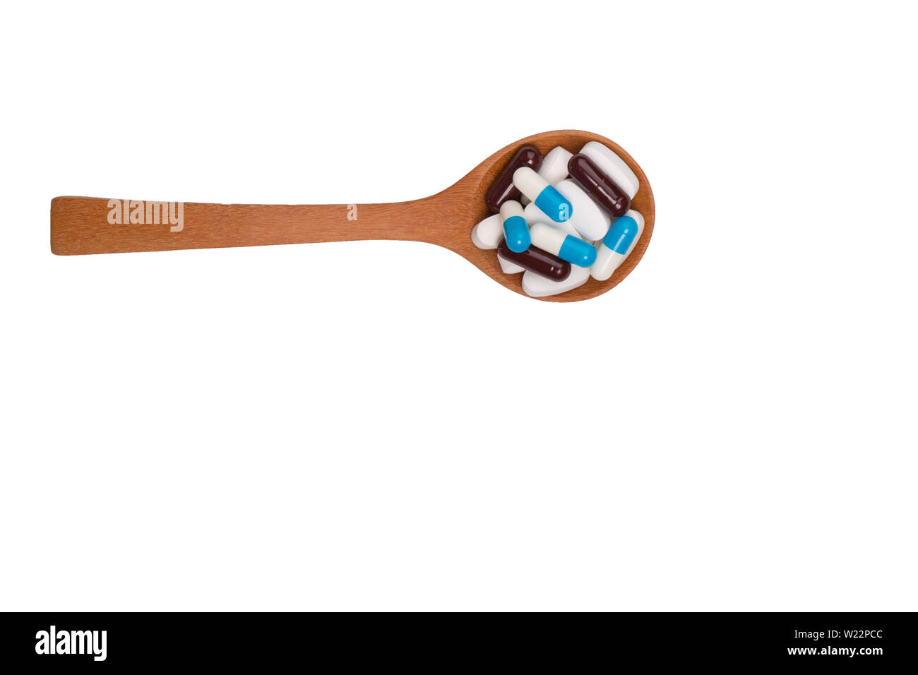 Tablet pill on wood spoon isolated on white background Stock Photo - Alamy