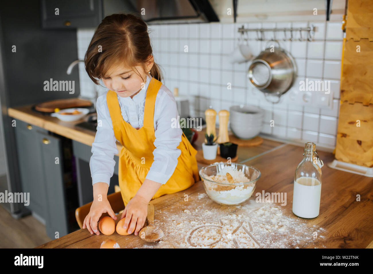 Little cute girl getting ready to bake a cake in kitchen Stock Photo ...