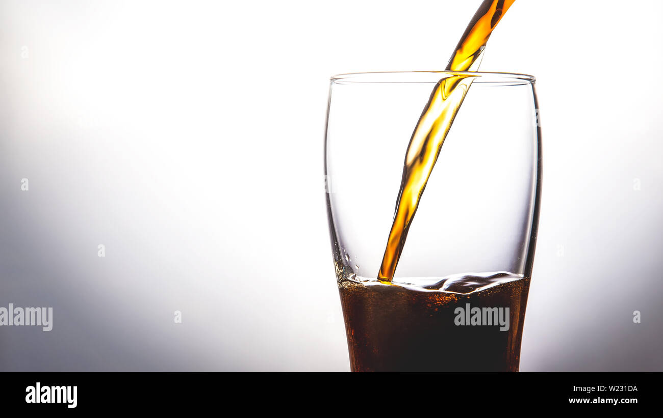 pouring cola into glass with ice on white background Copy space Place ...