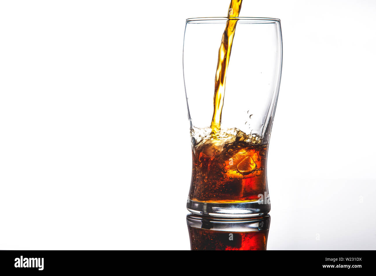 pouring cola into glass with ice on white background Copy space Place ...