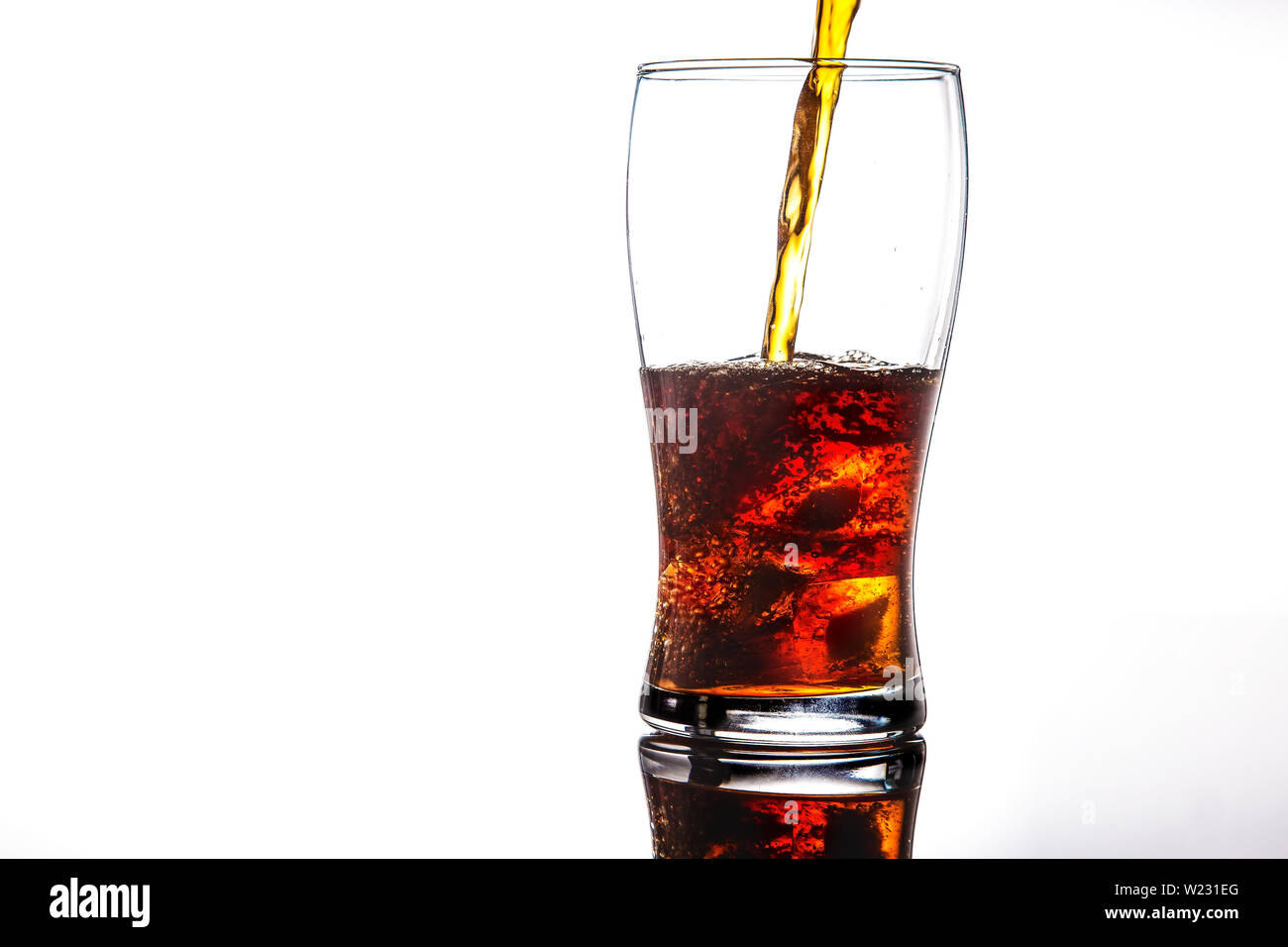 pouring cola into glass with ice on white background Copy space Place ...