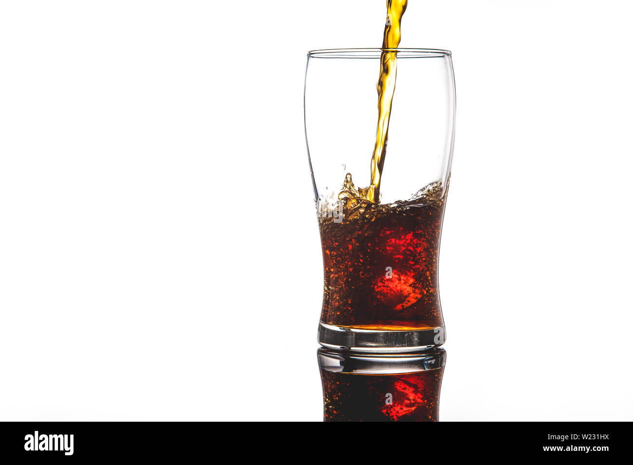 pouring cola into glass with ice on white background Copy space Place ...