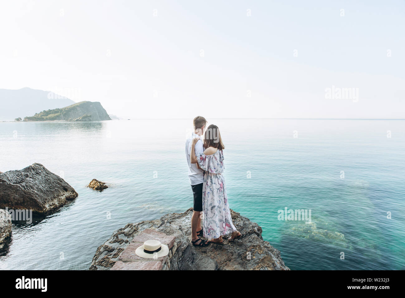 Young unrecognizable couple looks at the sea and hugs Stock Photo - Alamy