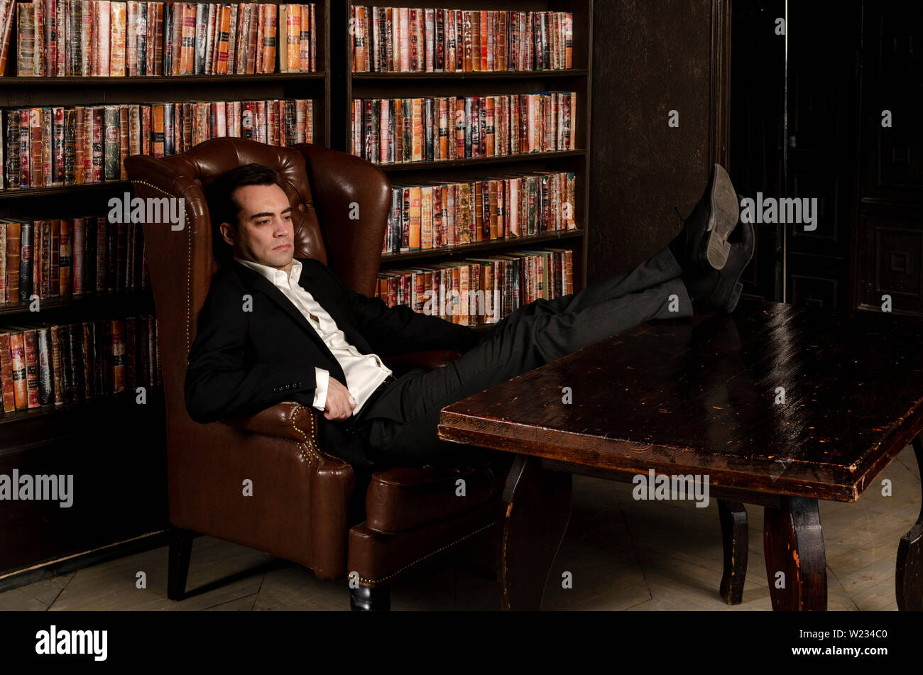 Handsome and attractive male in library full of books, looking ...