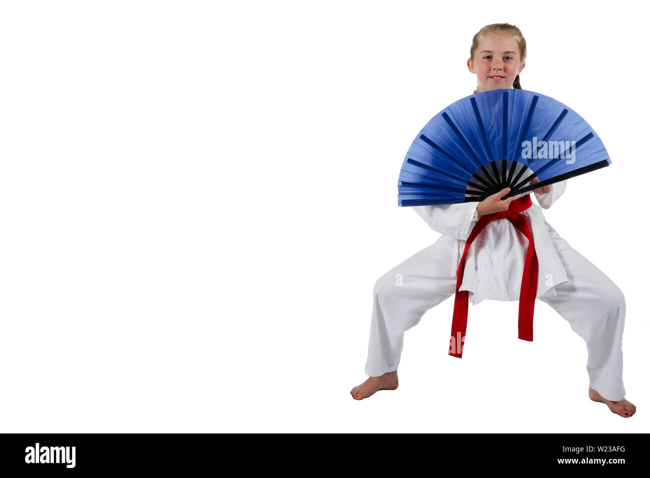 Pre-teen caucasian girl wearing a karate uniform with a fan Stock Photo ...
