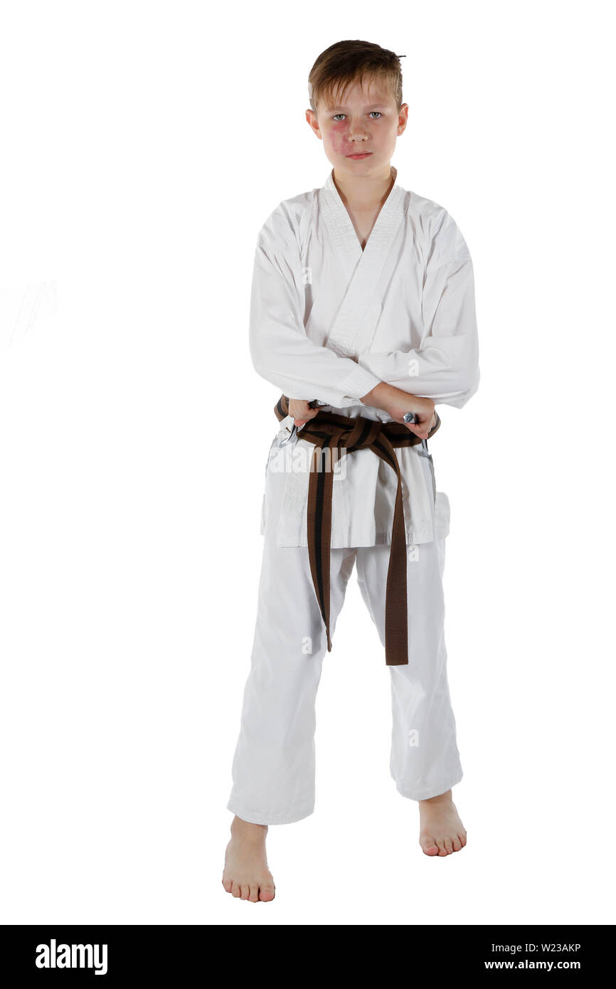 Teenage caucasian boy wearing a karate uniform performing kata with Sai ...
