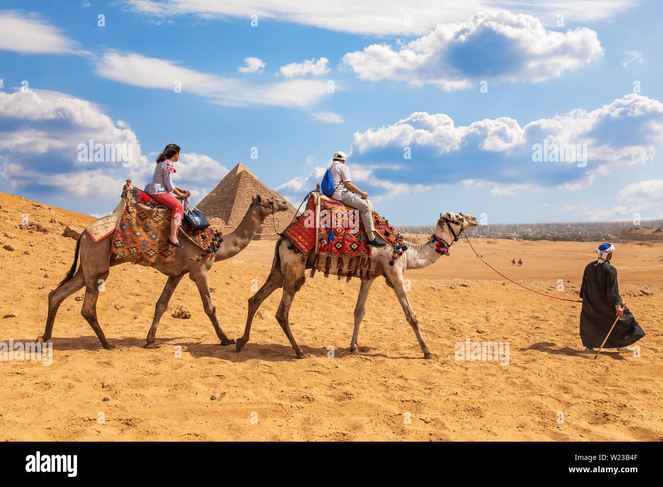 Tourists riding camels near the Pyramids of Giza Stock Photo - Alamy