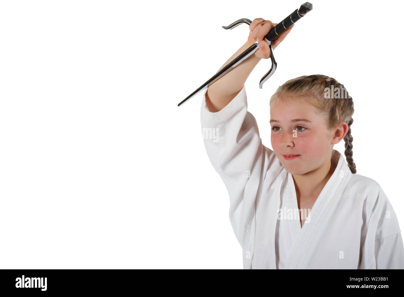 Pre-teen caucasian girl wearing a karate uniform using Sai Stock Photo ...