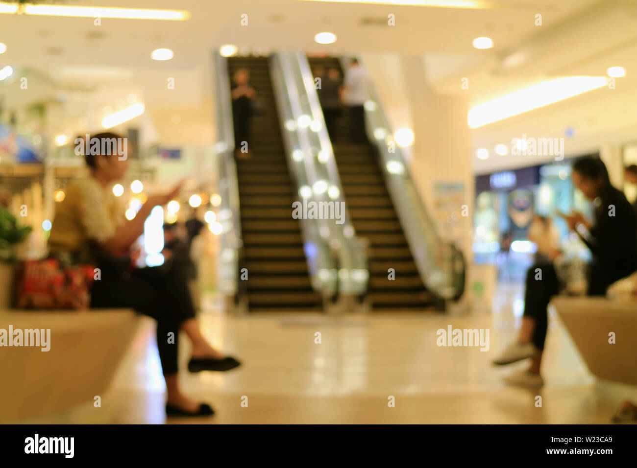 Blurred of people using their mobile phone in the lobby of shopping ...