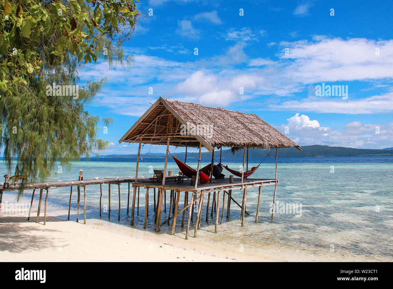 Stilt platform with hammocks over the water on a tropical beach in Raja ...