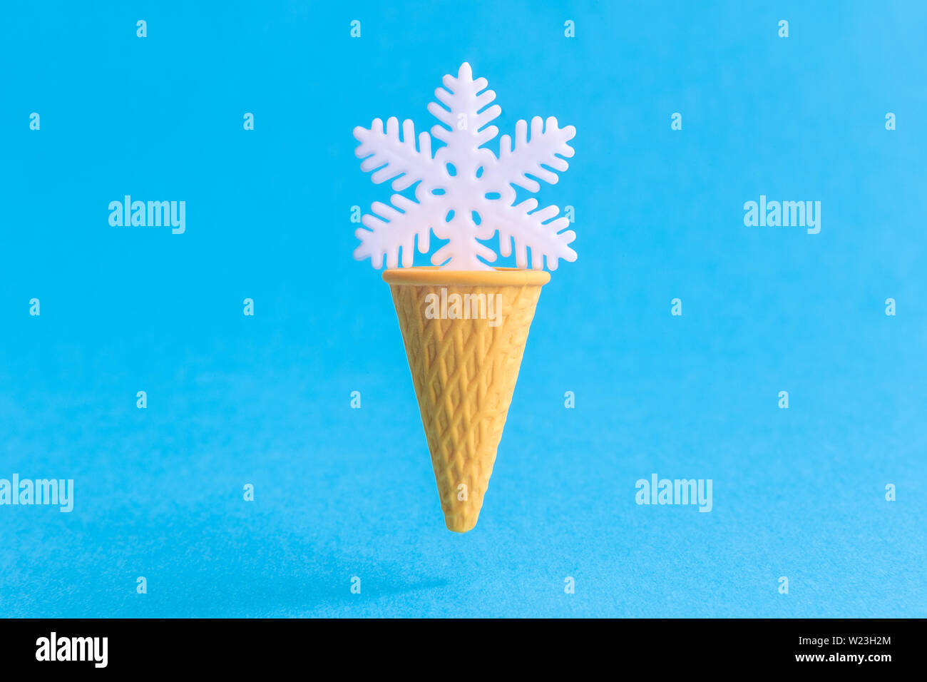 Snowflake in ice cream cone against blue background minimal winter ...